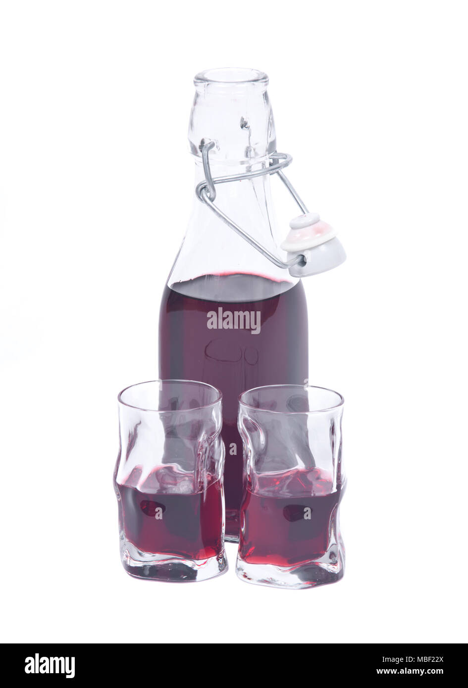 Homemade raspberry liqueur in clear glass bottle with swing top and ...