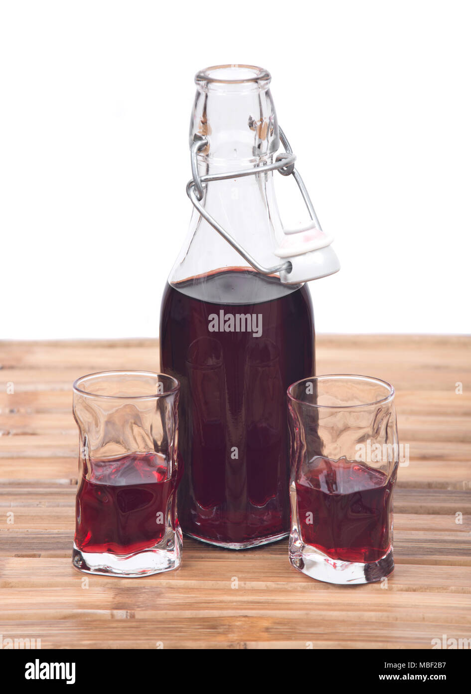 Homemade raspberry liqueur in clear glass bottle with swing top and ...