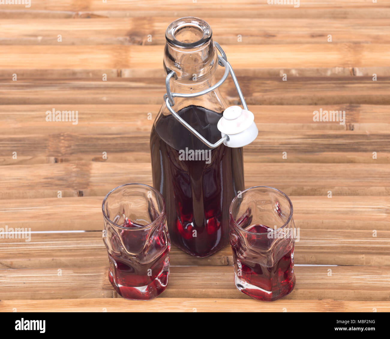 Homemade raspberry liqueur in clear glass bottle with swing top and ...