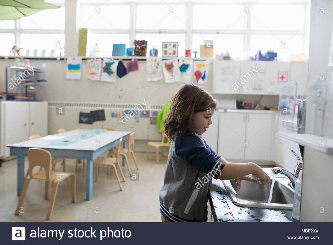 Preschool girl washing hands at sink in classroom Stock Photo - Alamy