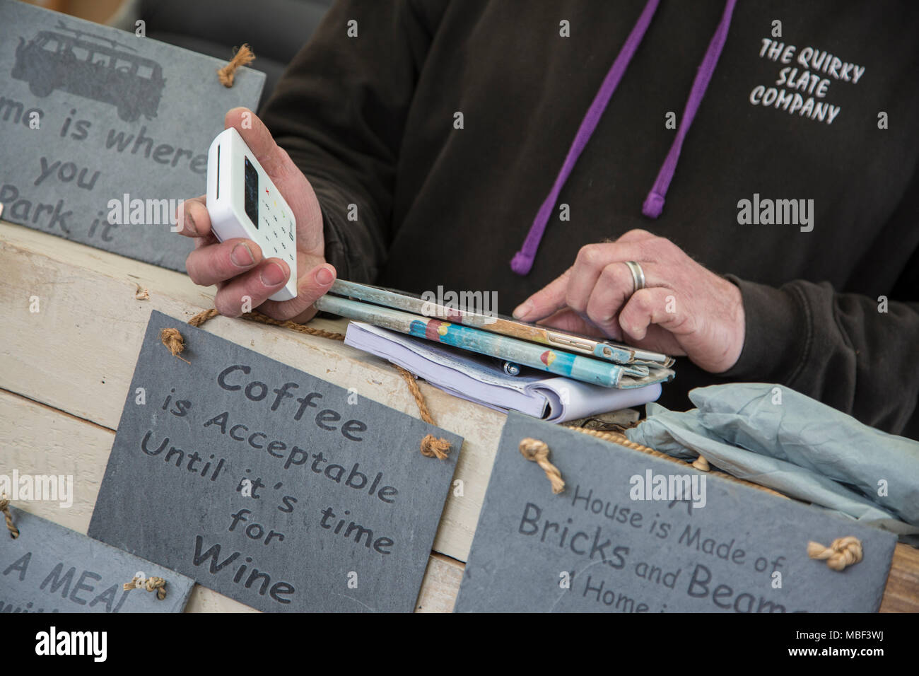market stall trader taking a payment on a handheld card reader at ...