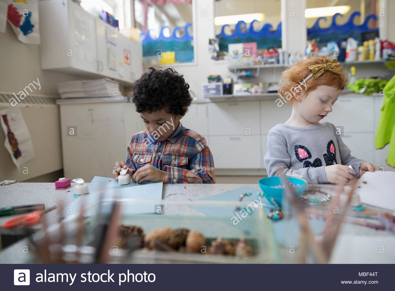 Preschool boy and girl making art and craft projects in classroom Stock ...