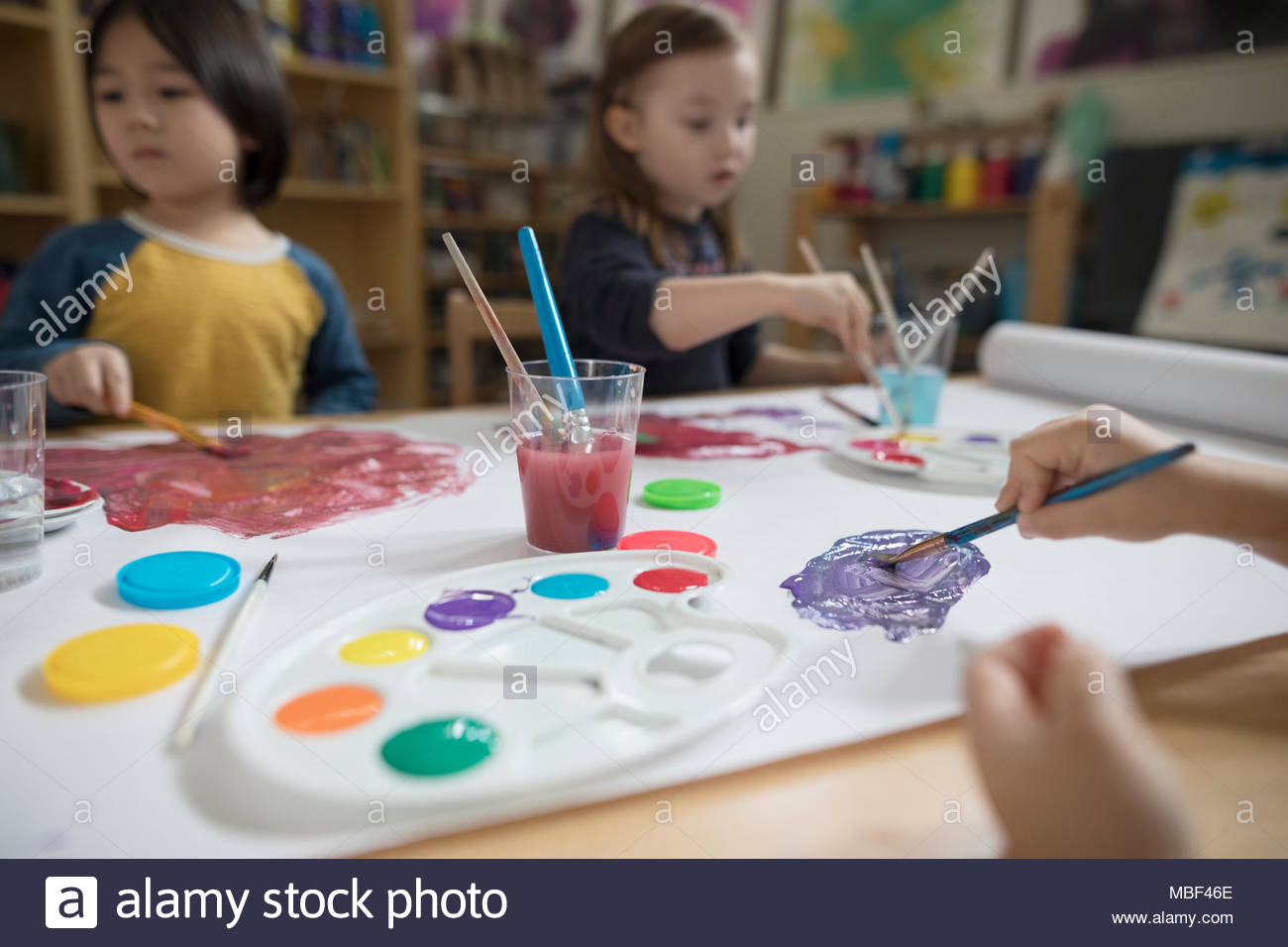 Preschool boy and girl painting in art classroom Stock Photo - Alamy