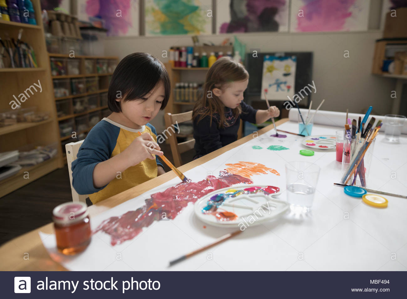 Preschool boy and girl painting in art class Stock Photo - Alamy