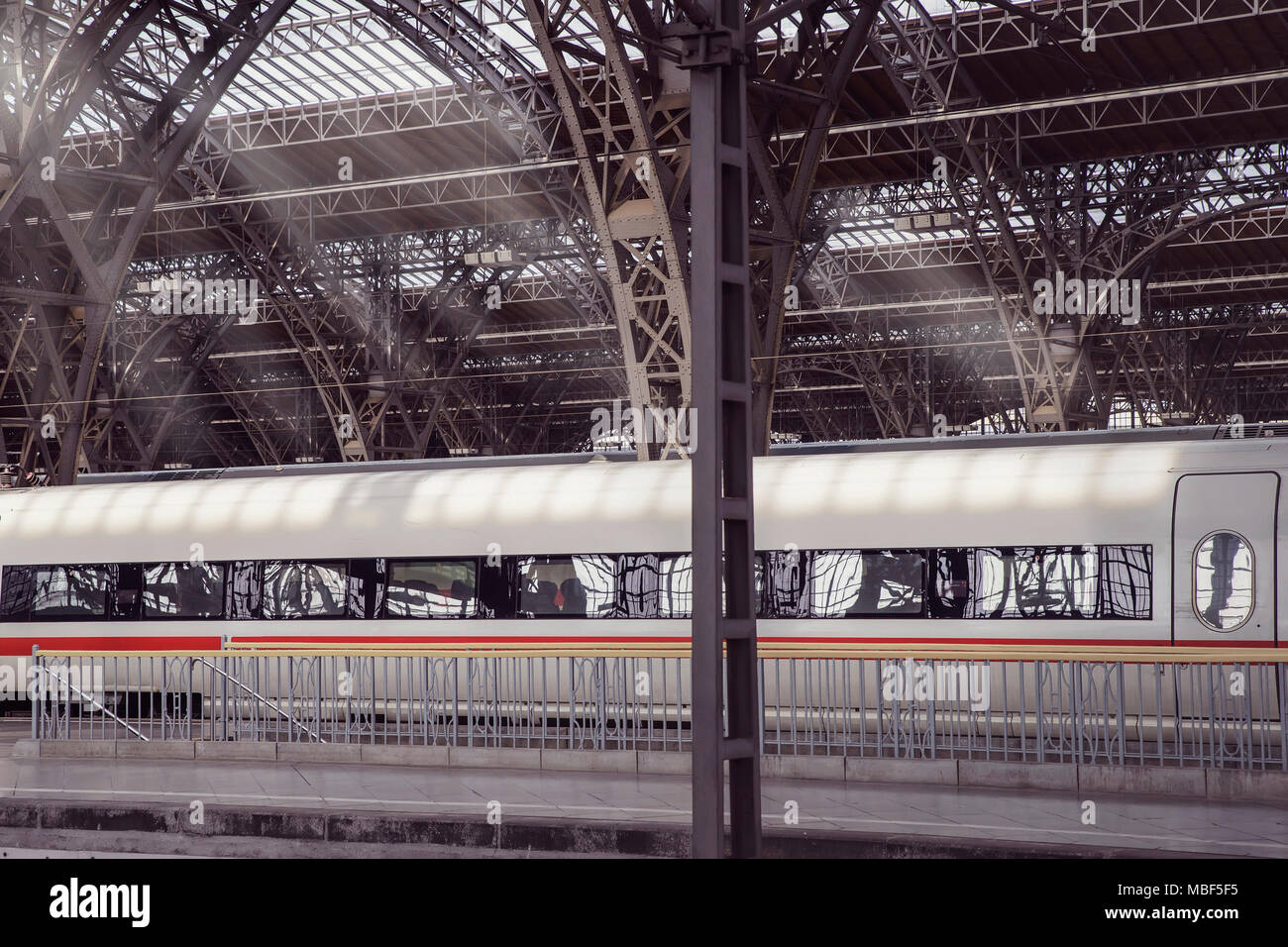 fast train stands at the station waiting for passengers in the light of ...