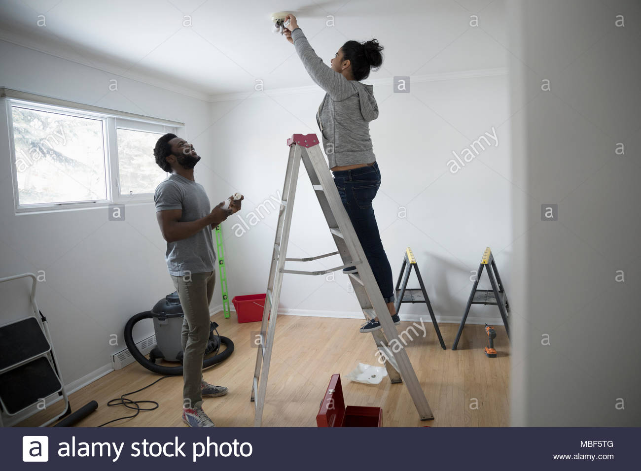 Man changing light bulb on ladder hi-res stock photography and images ...