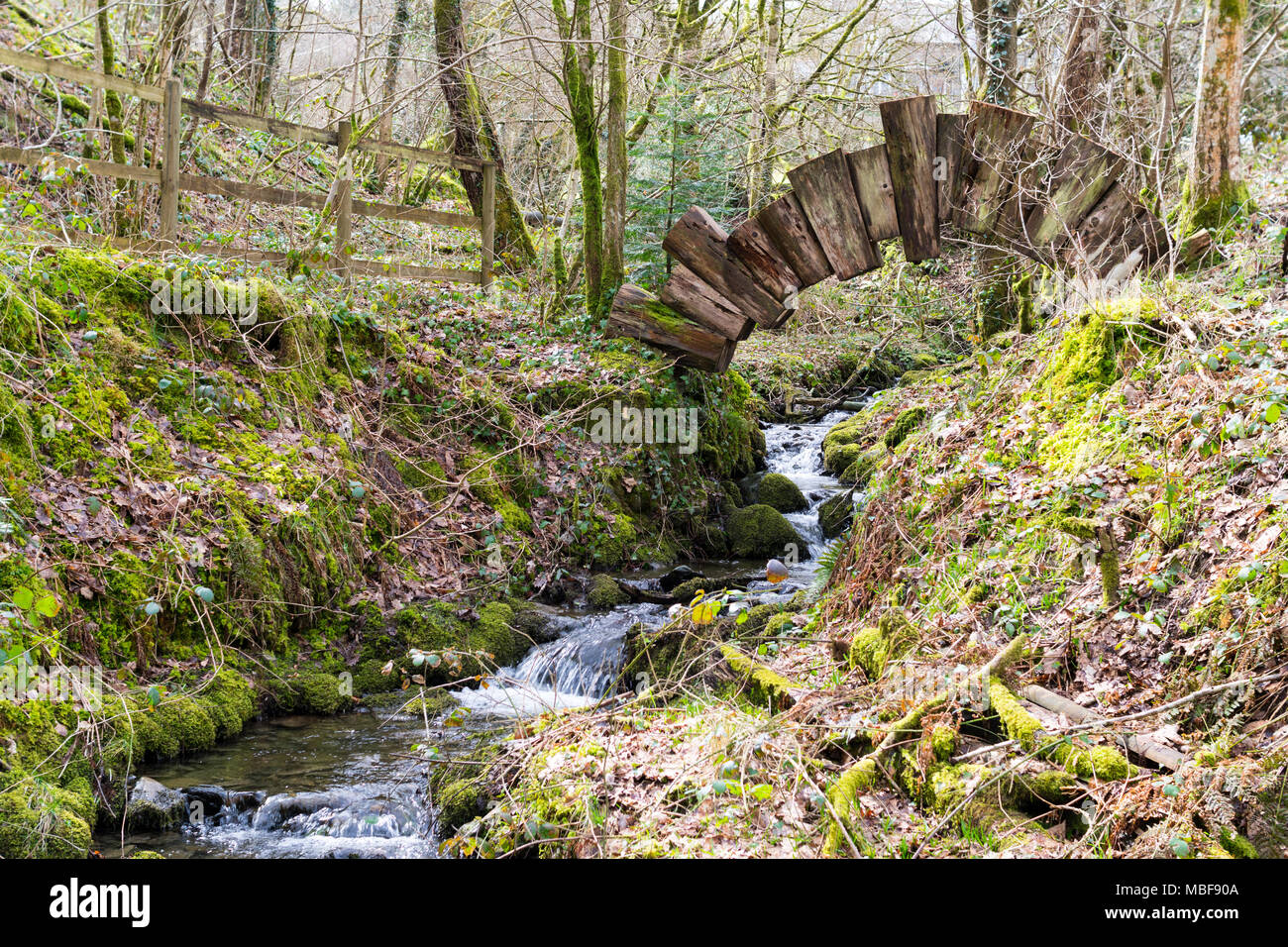 Wooden arch and gentle cascading stream with steep banks, near Lake ...