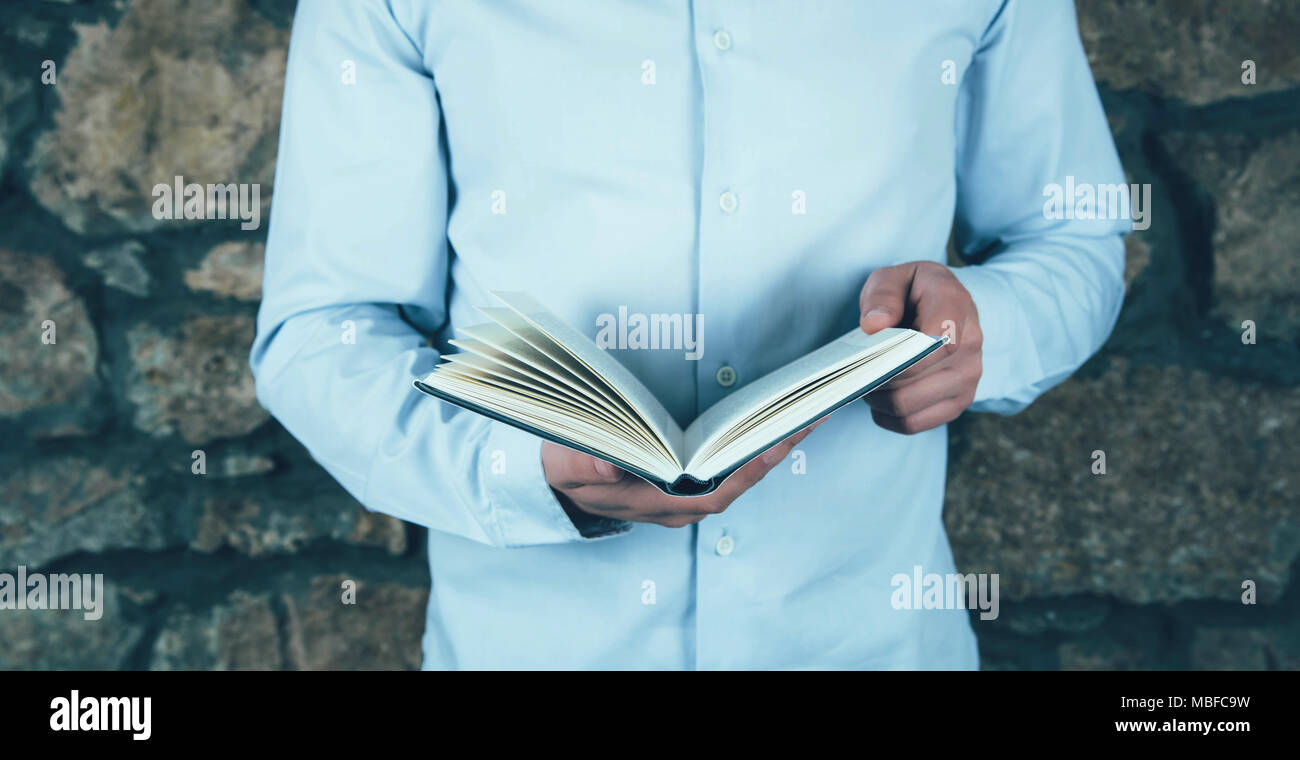 Young man opening and reading a book Stock Photo - Alamy