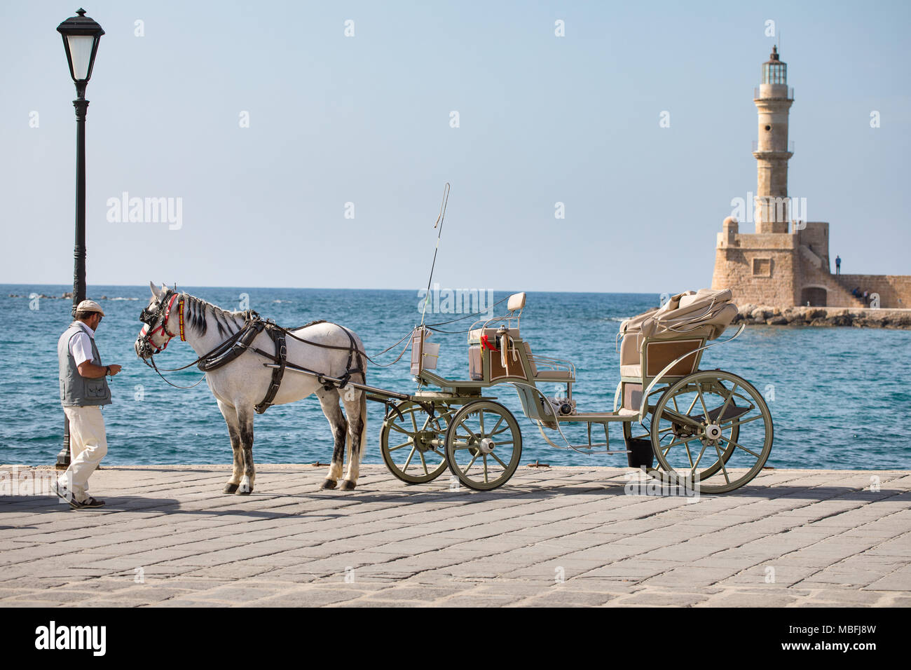 Open carriage and a horse in Chania harbor, cityscape, and medieval ...