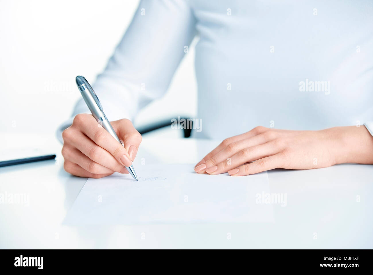 Close-up shot of businesswoman's hand holding pen and sign the paper ...