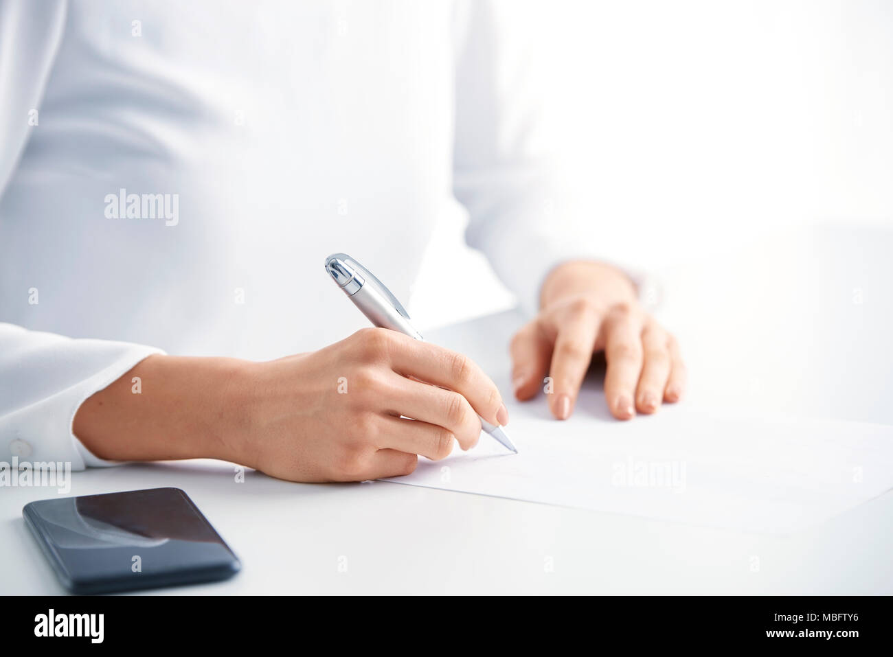Close-up shot of businesswoman's hand holding pen and sign the paper ...