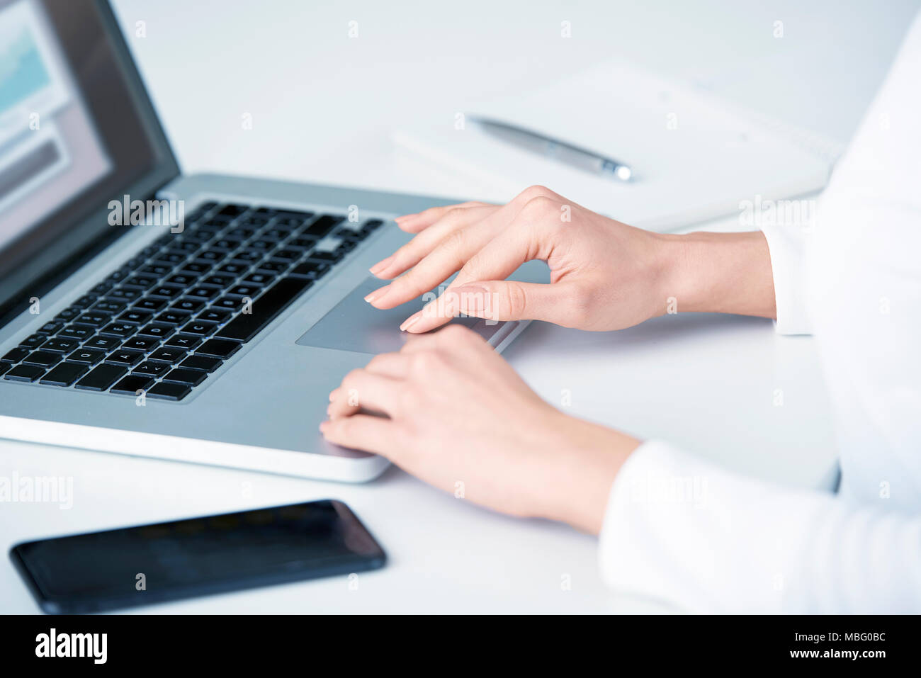 Close-up of businesswoman's hand typing on laptop's keyboard while ...