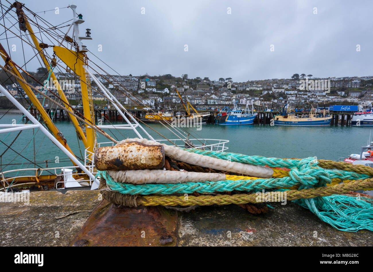 Ropes tied to a bollard on the harbour wall at Newlyn in cornwall ...