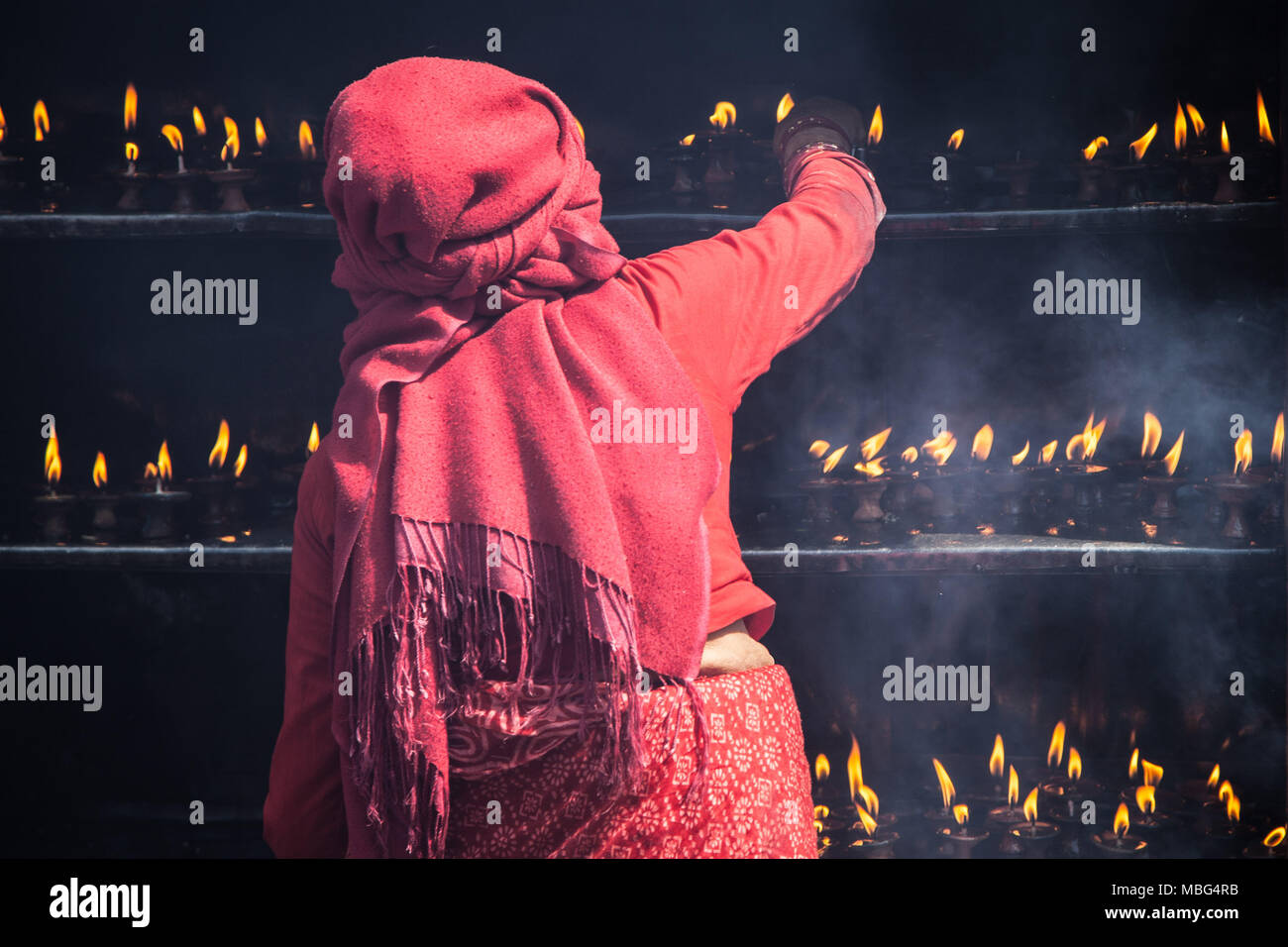 Old lady lighting butter lamps at Swayambunath monkey temple, Kathmandu ...