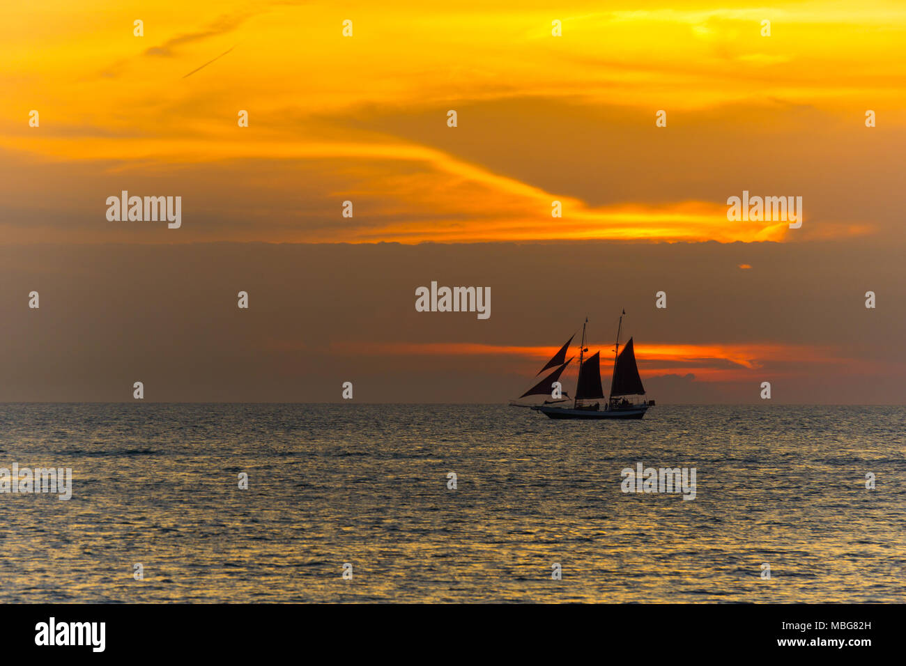 USA, Florida, Red colorful dramatic sunset behind sailing ship Stock ...