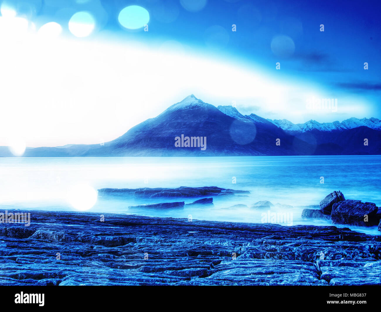 Abstract effect. Rocks and boulders on shore. Poor warm sunset light ...