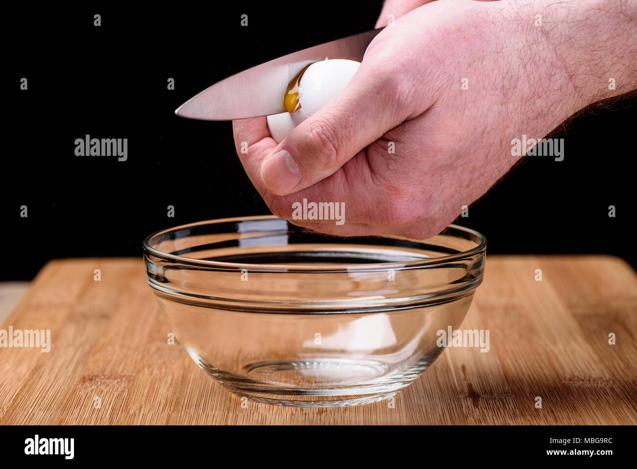 A man is breaking an egg. Chicken egg. Yolk from a broken shell Stock ...