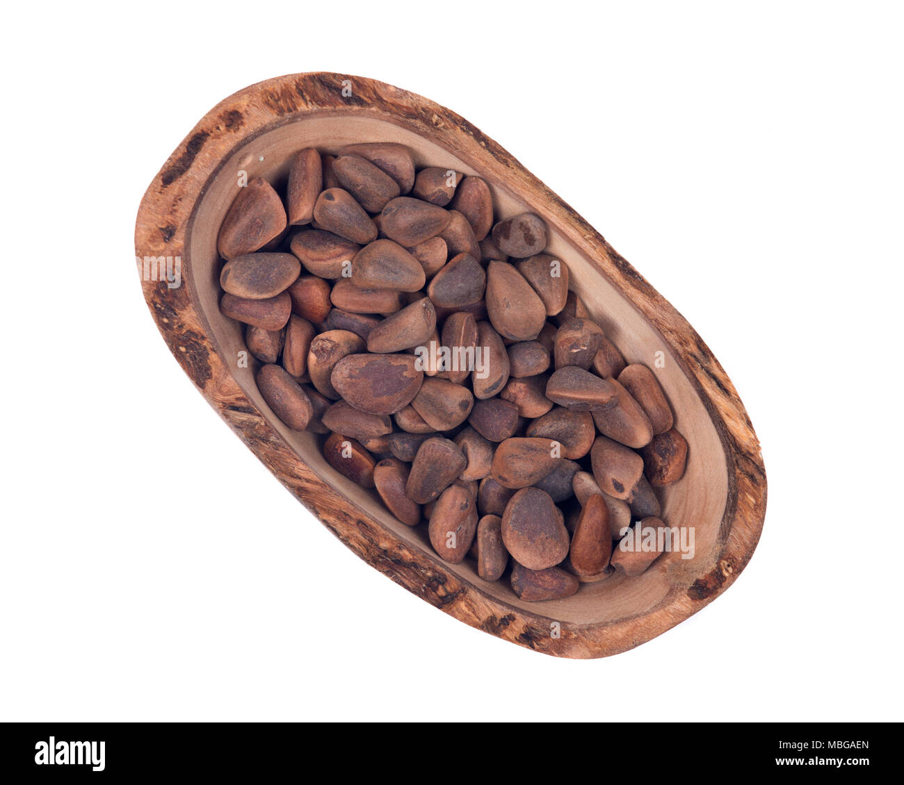Organic pine nuts in shell in olive wood bowl Stock Photo - Alamy