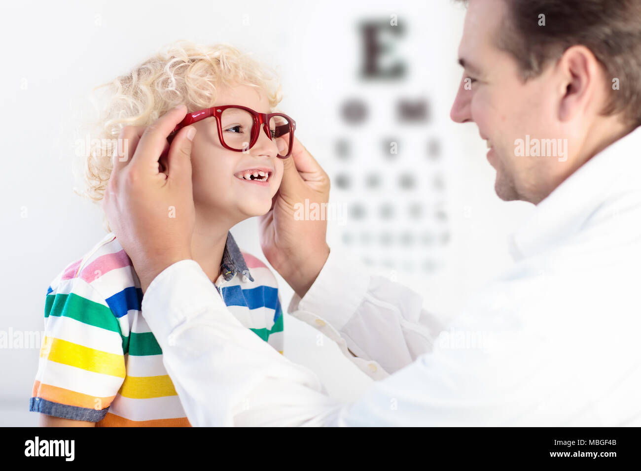 Child at eye sight test. Little kid selecting glasses at optician store ...