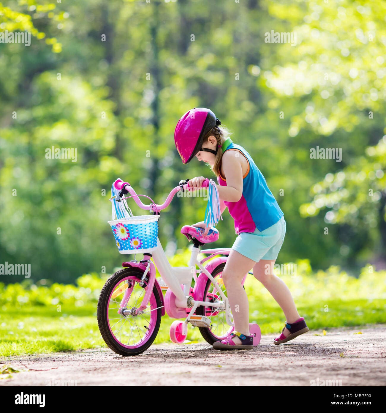 Child riding bike. Kid on bicycle in sunny park. Little girl enjoying ...