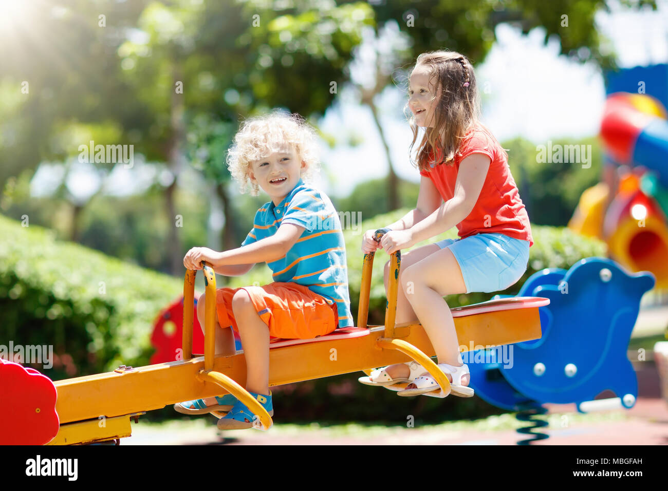 Kids climbing and sliding on outdoor playground. Children play in sunny ...