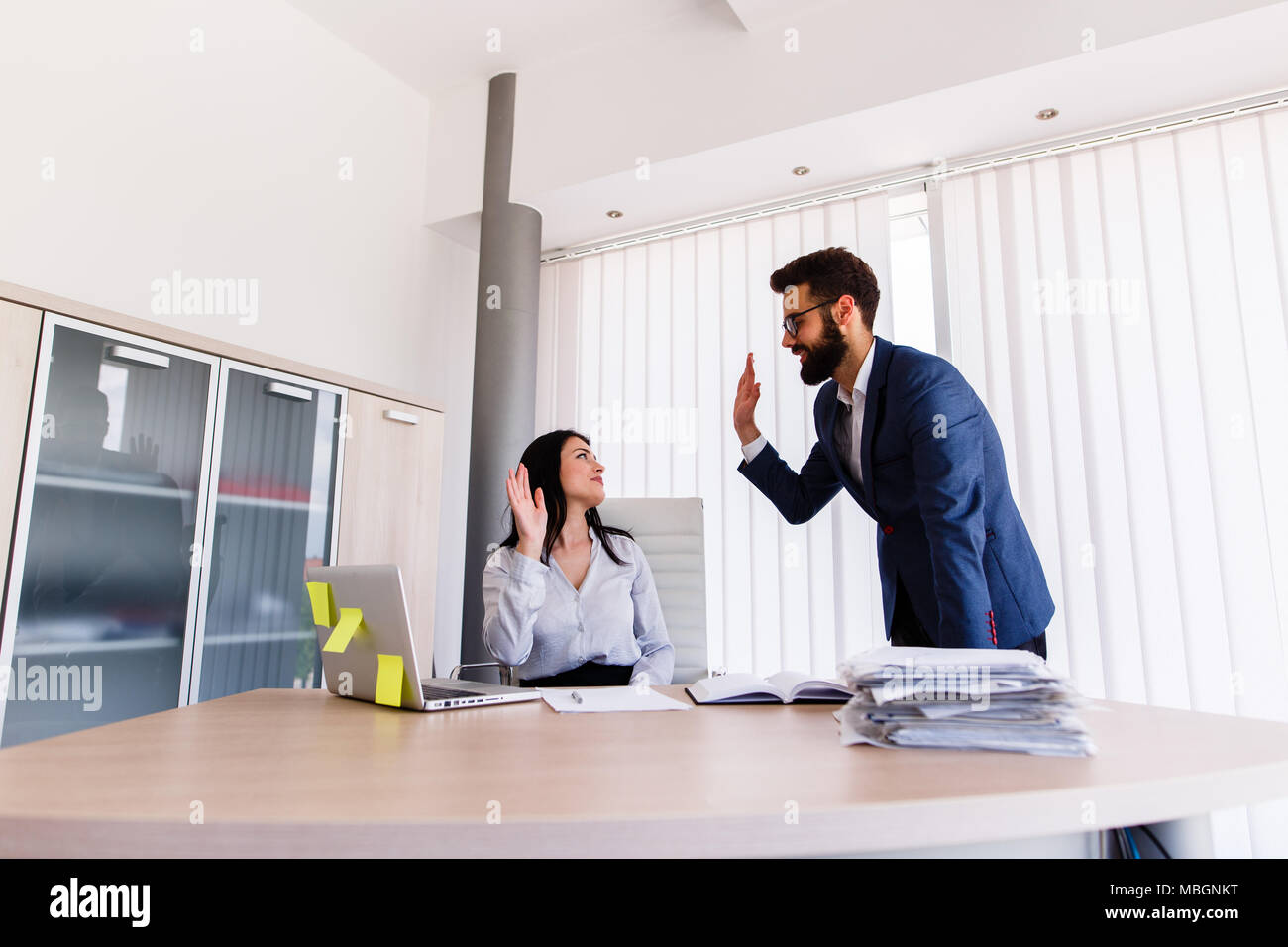 Business couple doing high five after successful work Stock Photo - Alamy