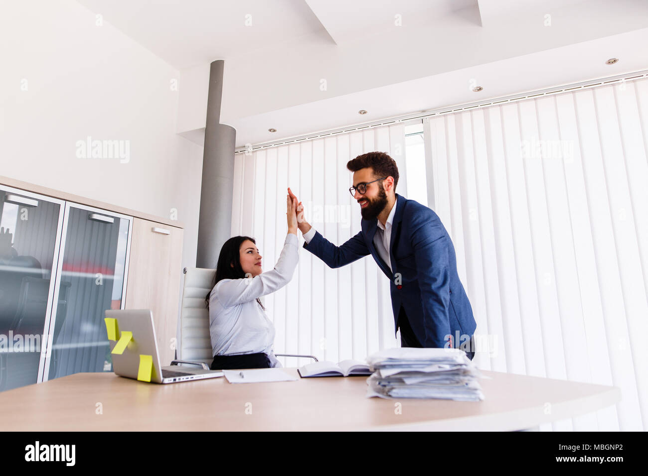 Business couple doing high five after successful work Stock Photo - Alamy
