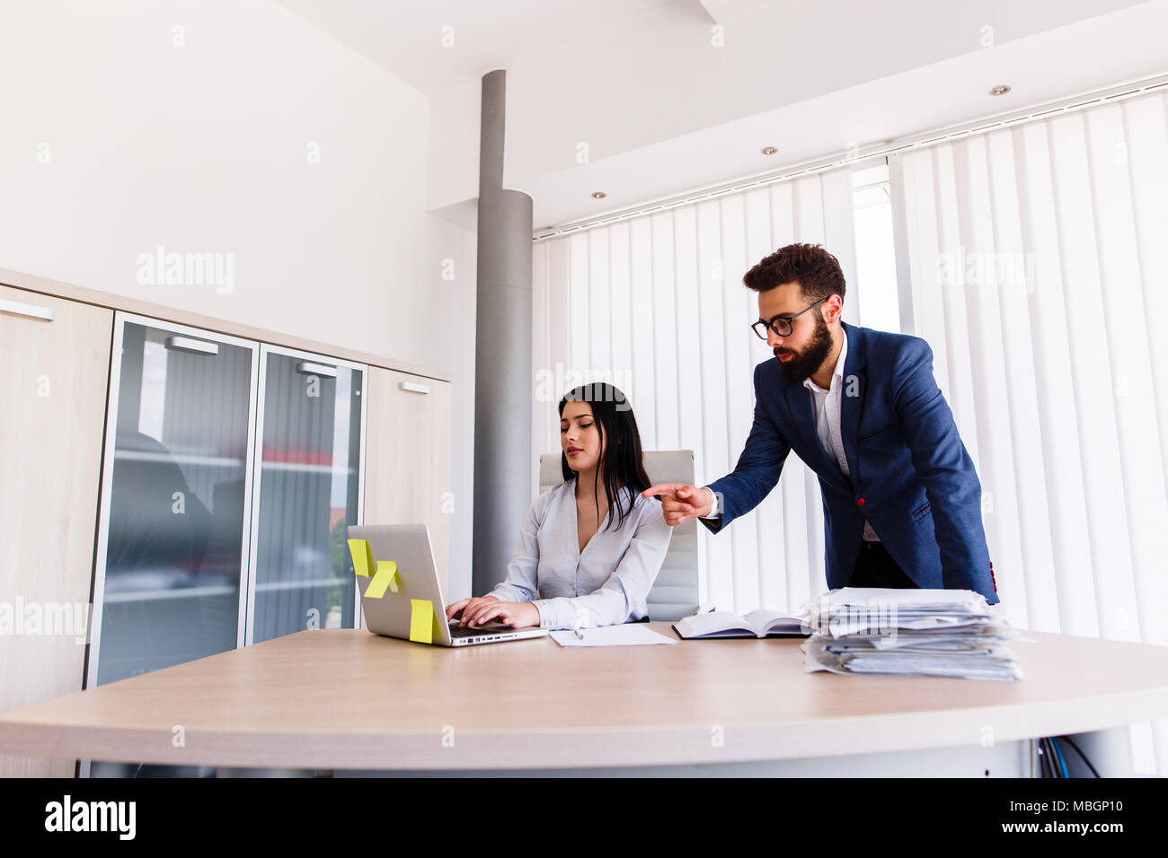 Business couple in office trying to get some work done using their ...