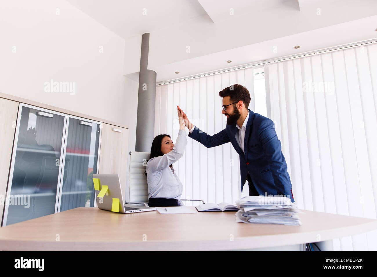 Business couple doing high five after successful work Stock Photo - Alamy