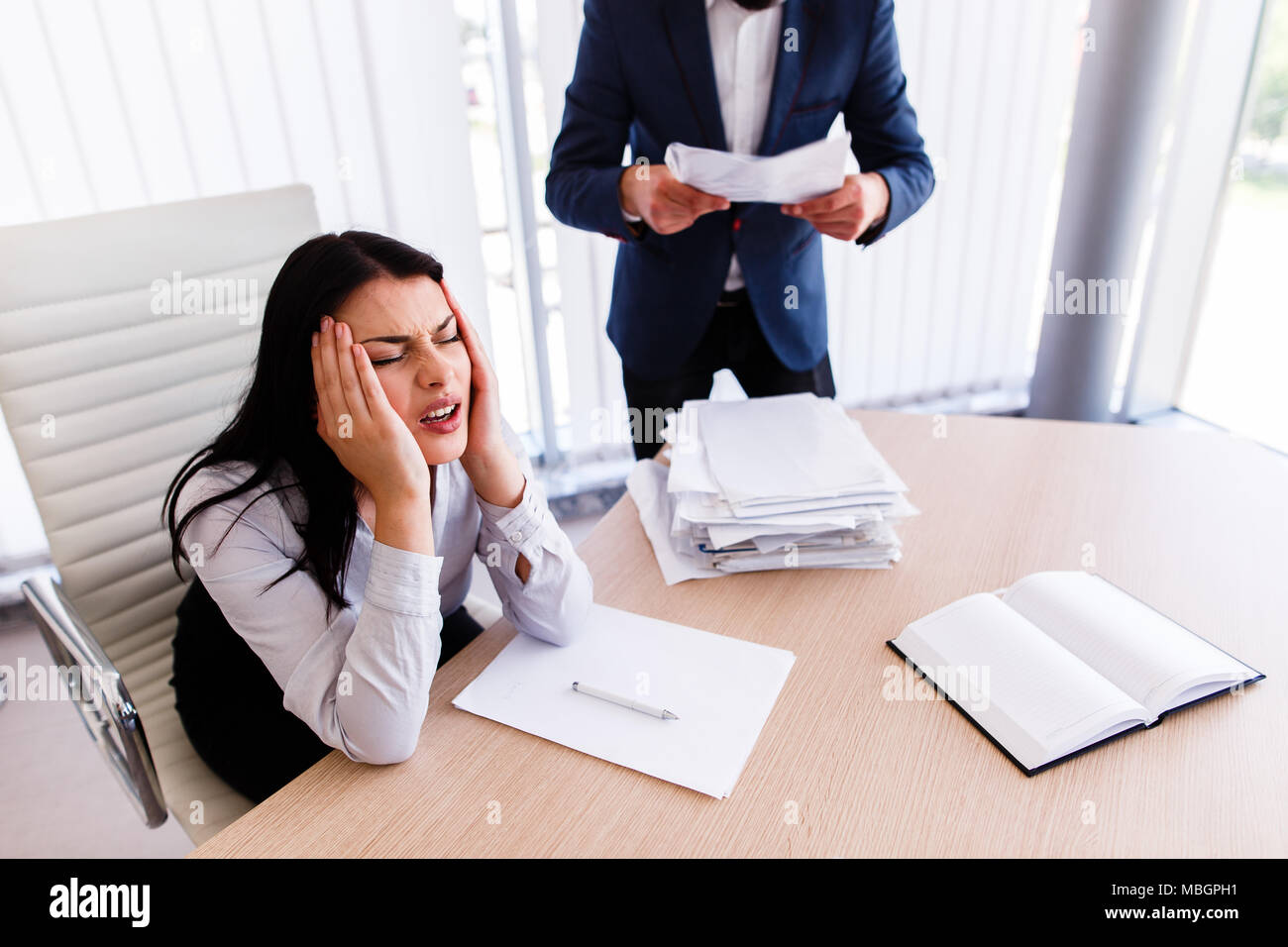 Businesswoman having headache for having too much work to get done from ...