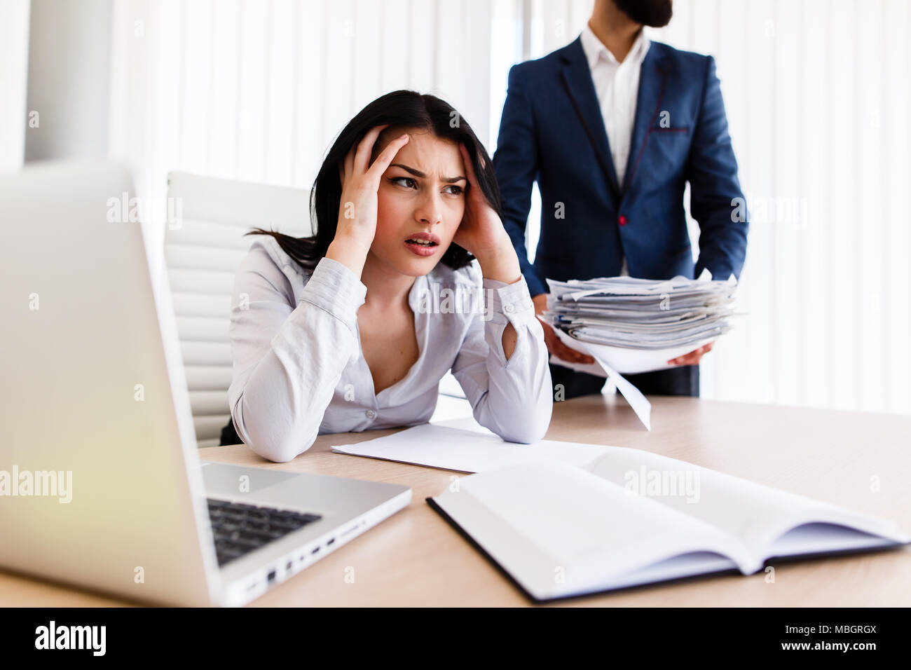 Businesswoman having headache for having too much work to get done from ...