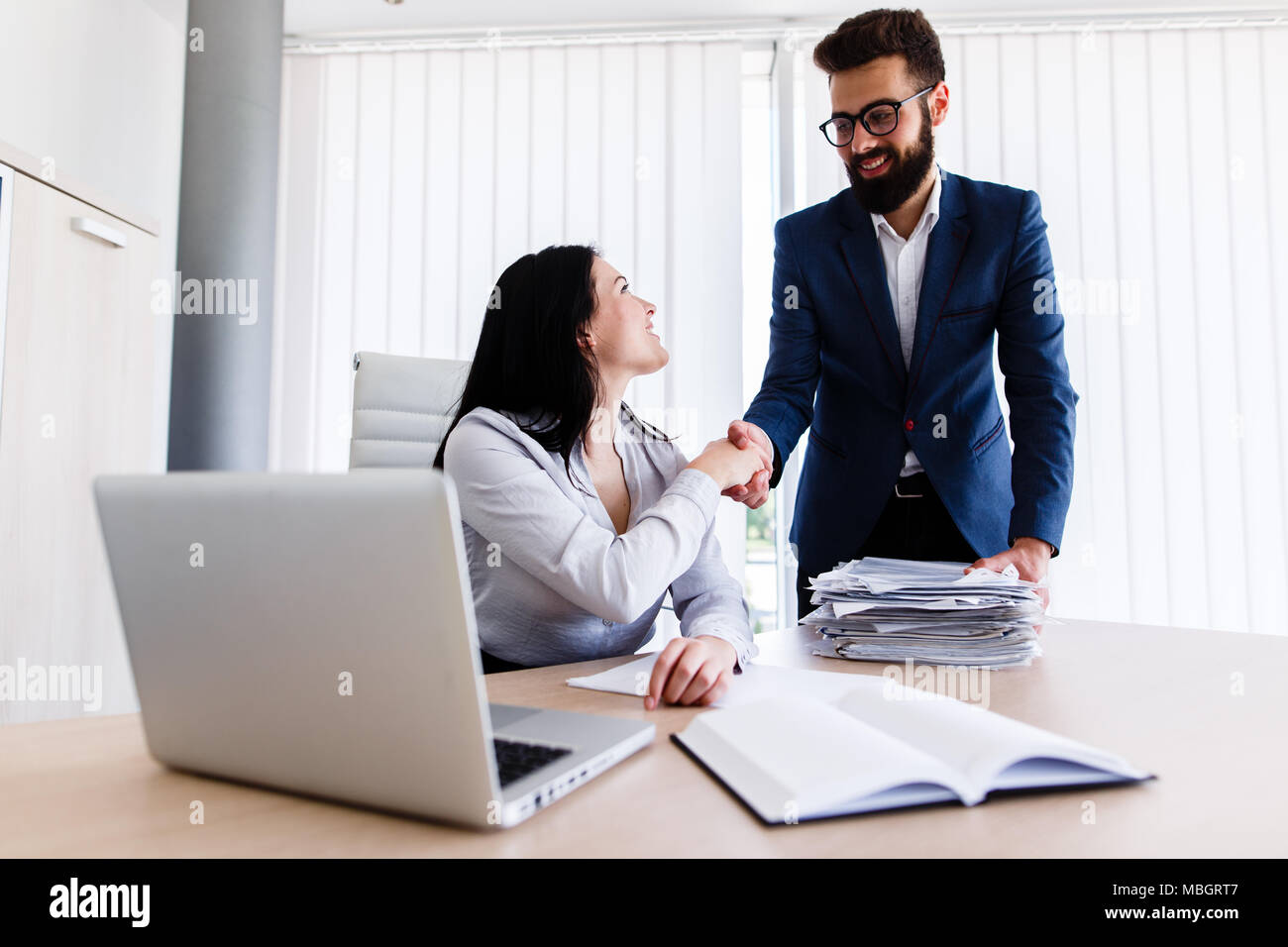 Business couple doing handshake after successful work Stock Photo - Alamy