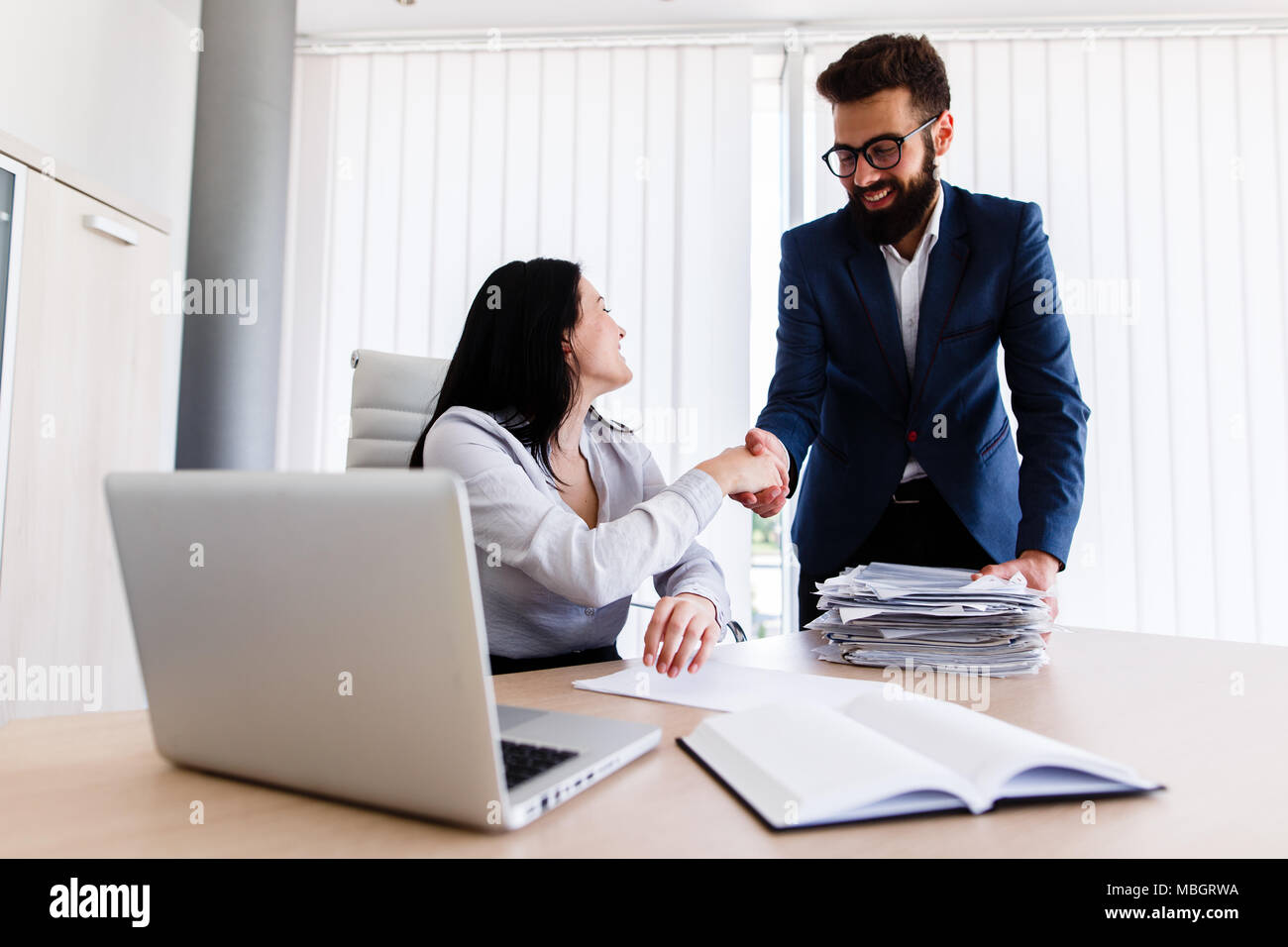 Business couple doing handshake after successful work Stock Photo - Alamy