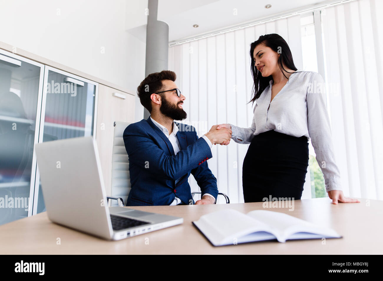 Business couple doing handshake after successfully done job Stock Photo ...