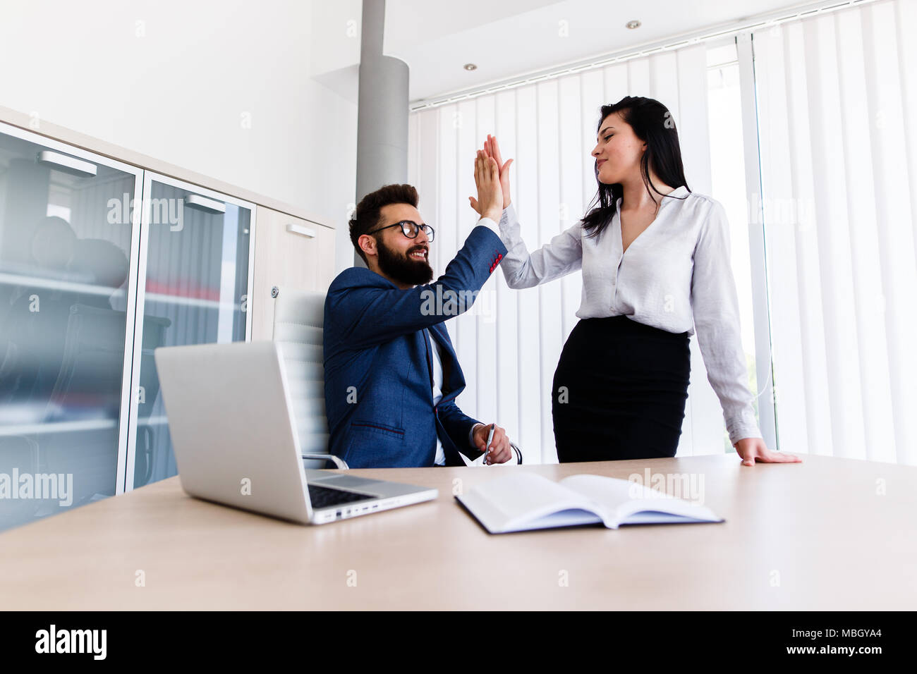 Business couple doing high five after successfully done job Stock Photo ...