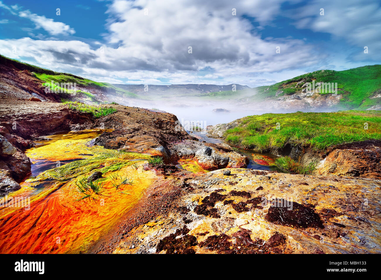 Geothermal area with very colorful deposits, a steaming hot water lake ...