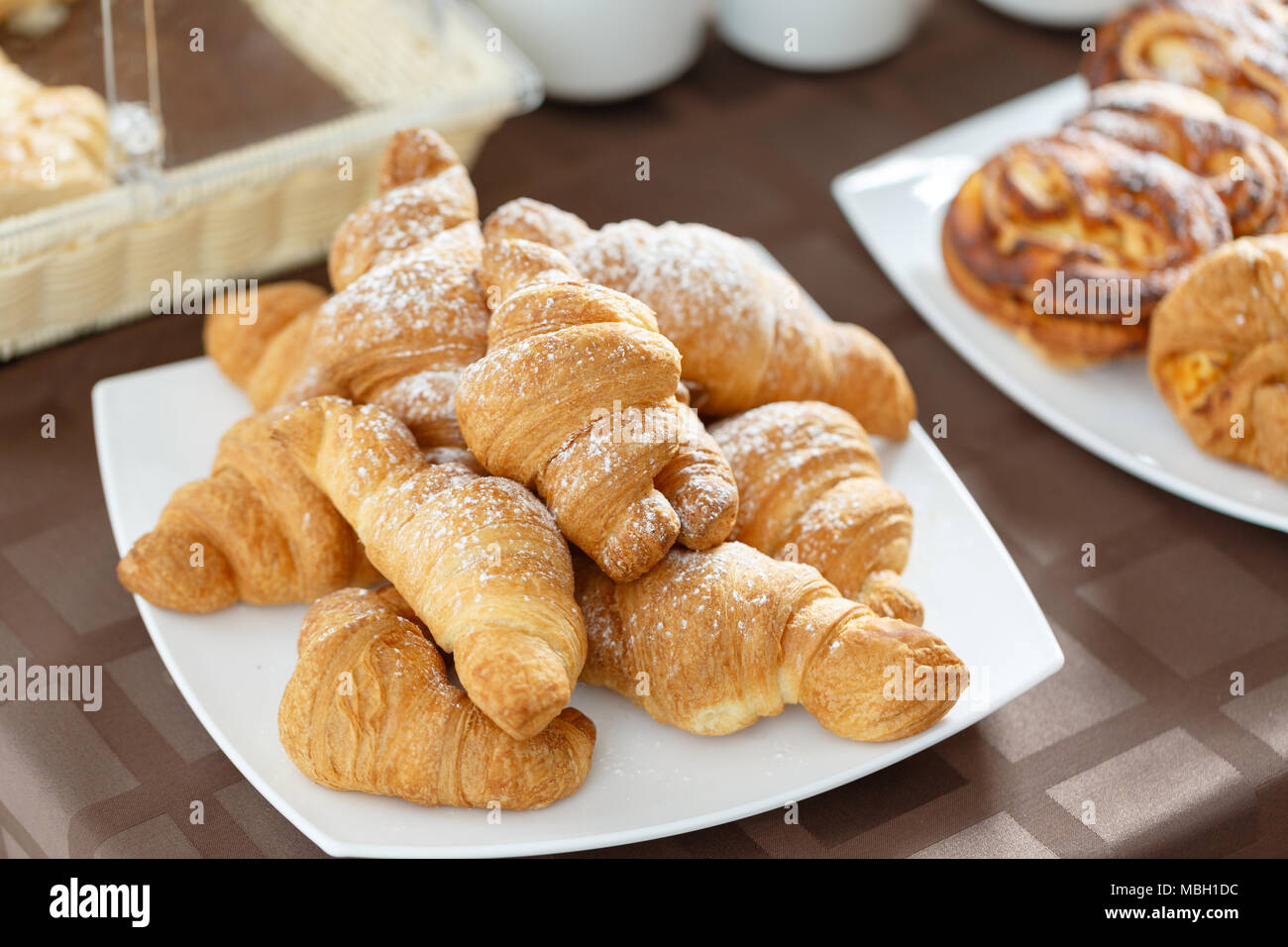 Fresh croissants on white plate. French traditional pastry. Breakfast ...