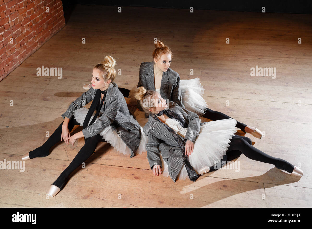 The ballet concept. Young ballerina girls relax sitting on the floor ...