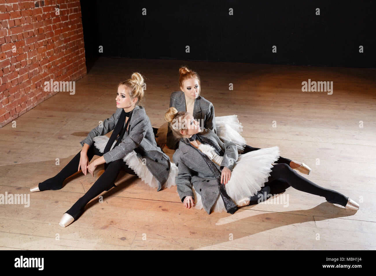 The ballet concept. Young ballerina girls relax sitting on the floor ...