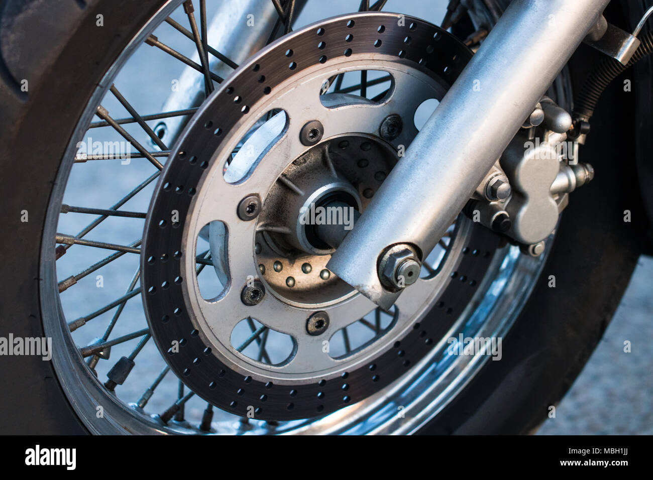Cropped shot of the shot of the motorcycle forks, tire and front wheel ...
