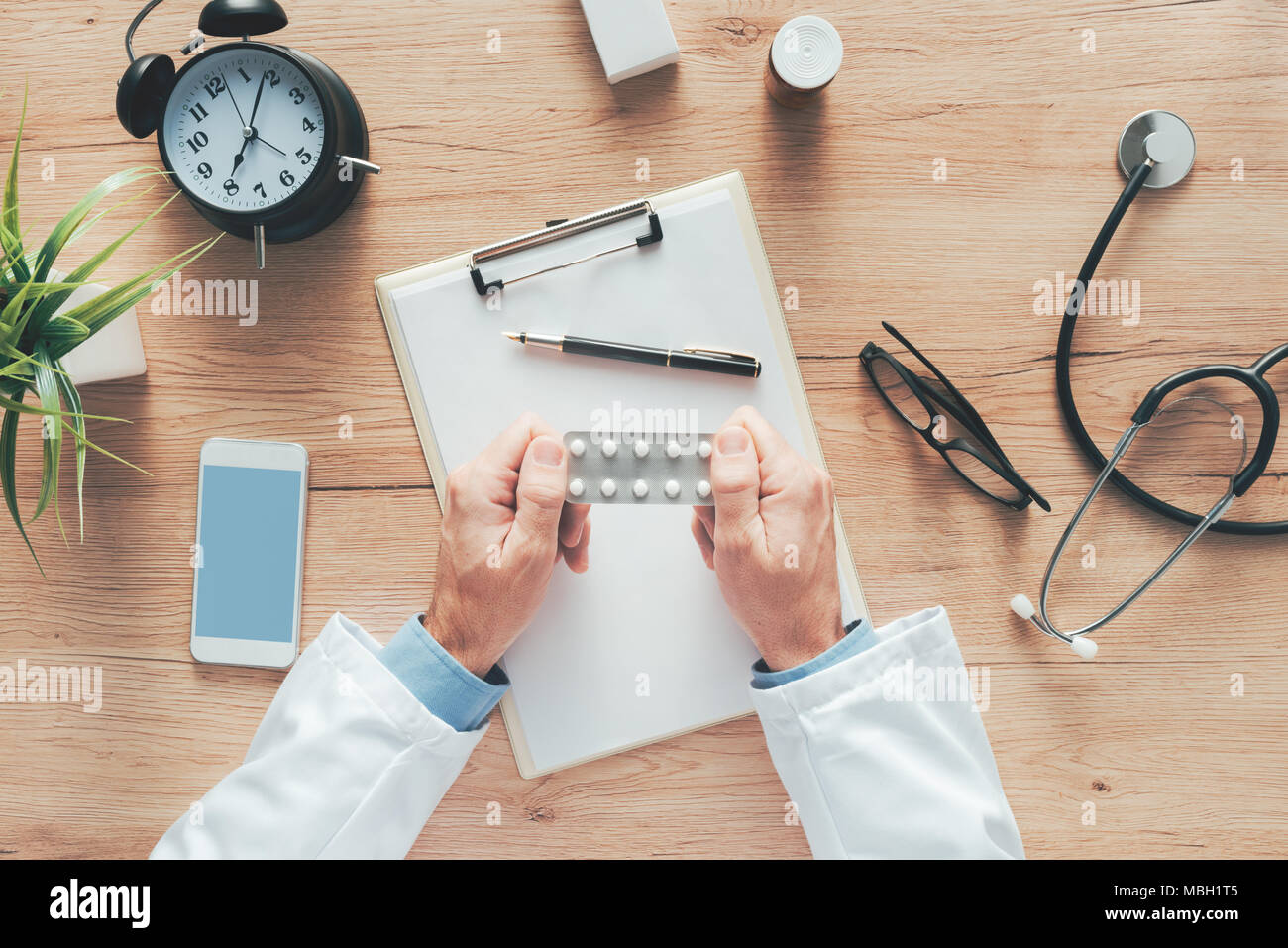 Male doctor holding unlabeled generic tablets and medication, generic ...