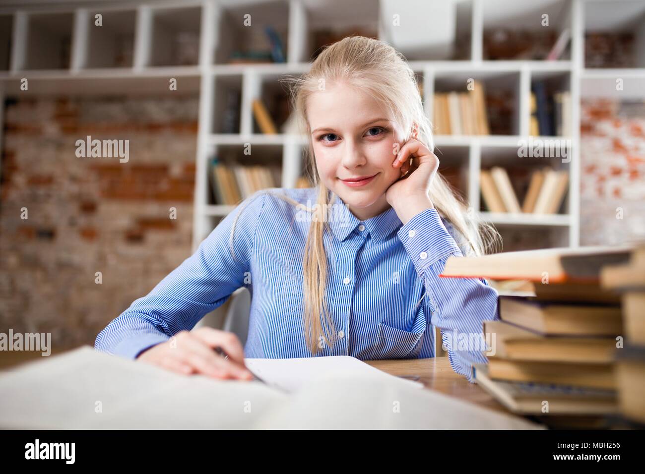 Teenage girl reading a book in library Stock Photo - Alamy
