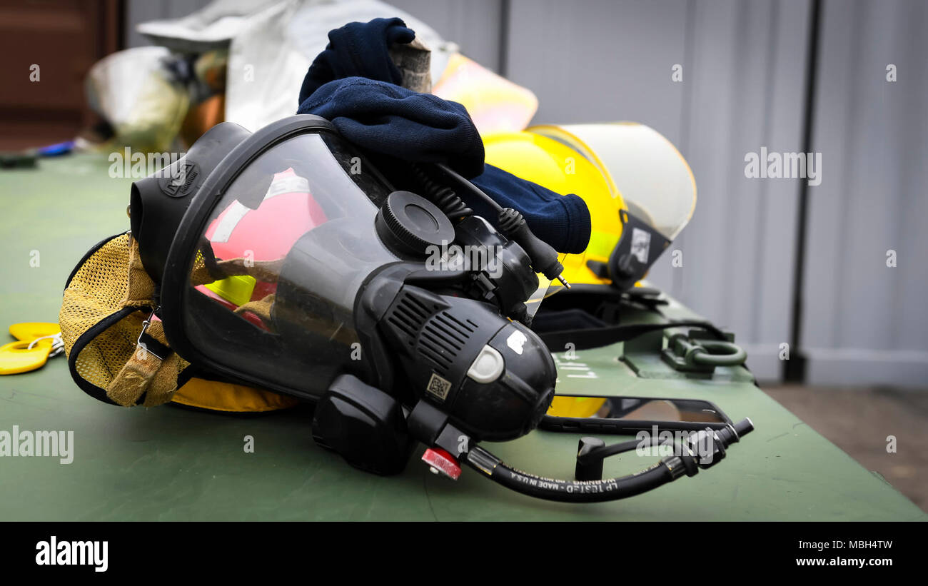 A gas mask and hood sit on a table during a live fire training exercise ...