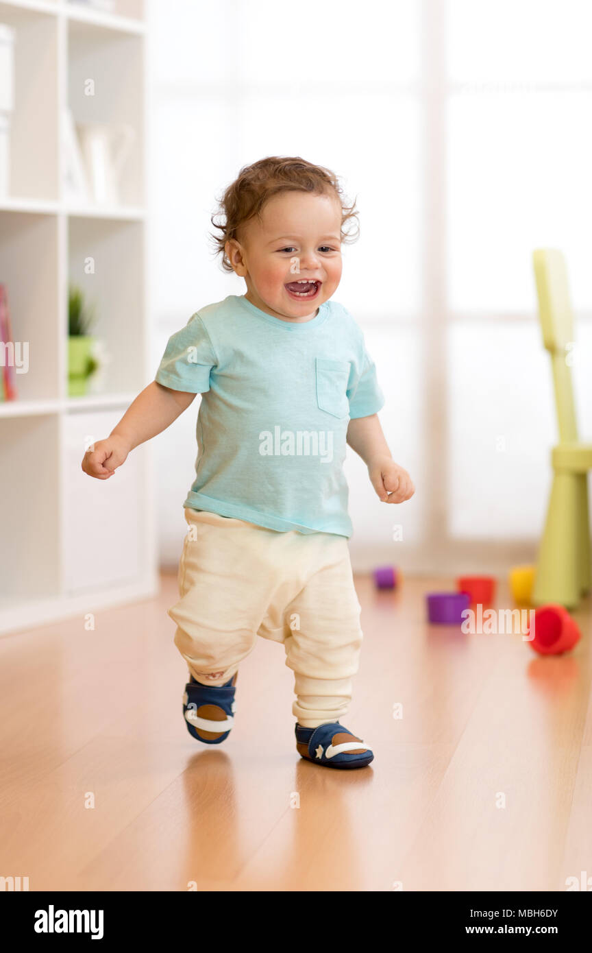 First steps of baby boy toddler learning to walk in living room ...