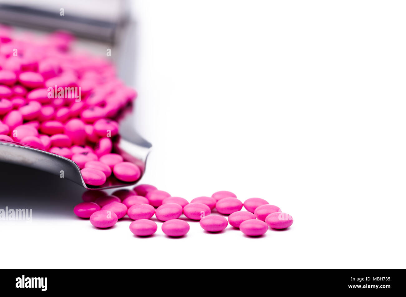 Pile of pink round sugar coated tablets pills on drug tray with copy ...