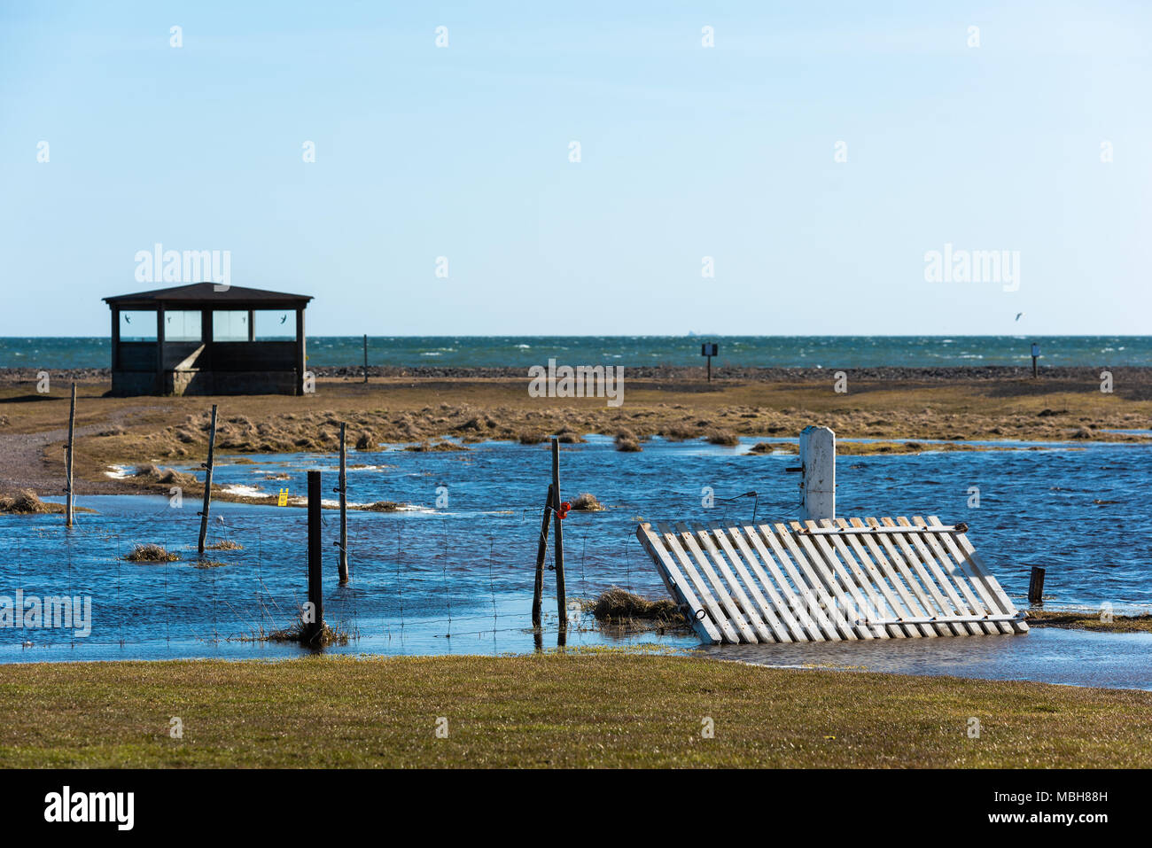 Path to distant birdwatching lookout shelter is flooded and the white ...