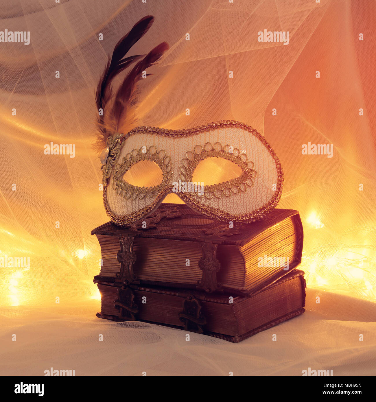 Image of elegant venetian mask over vintage old books in front of tulle ...