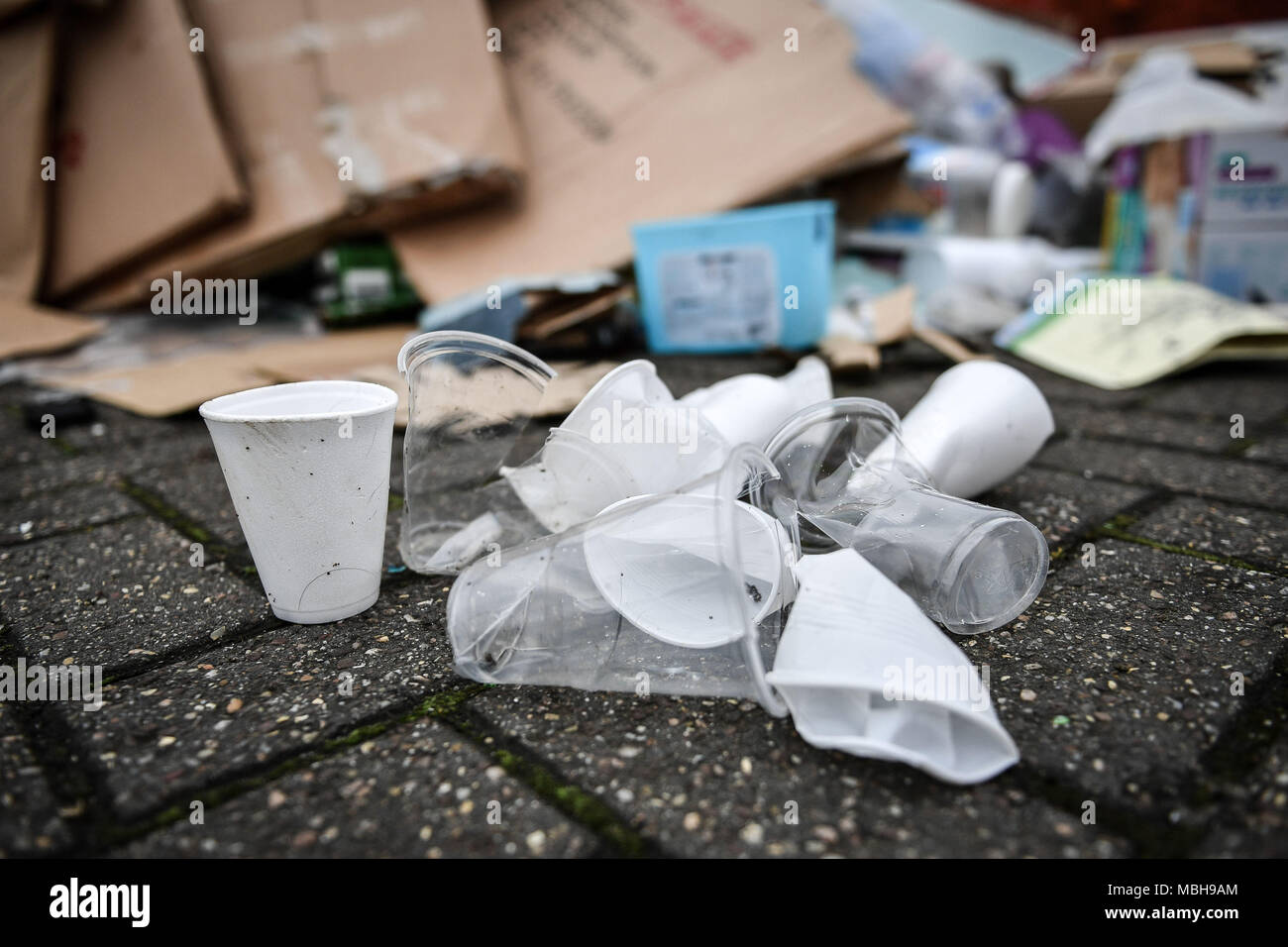 Used disposable drinking cups beside a rubbish pile of recyclable ...