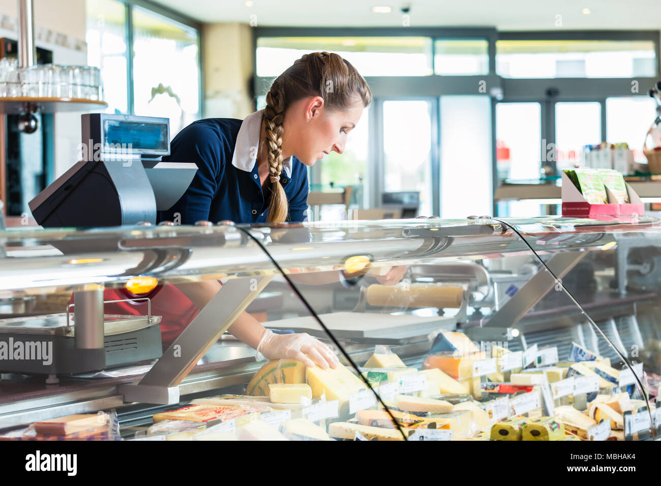Woman in butcher shop putting sausage and meat on sale Stock Photo - Alamy