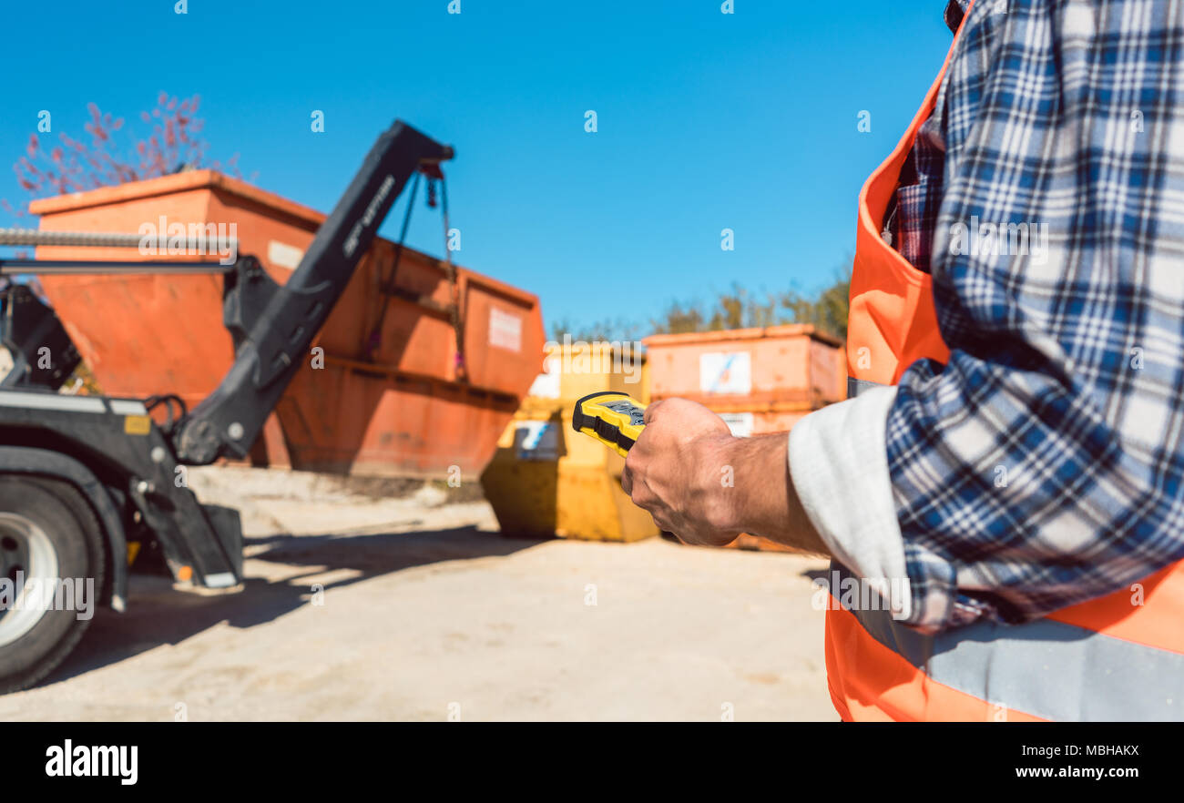 Man loading of construction debris container on truck Stock Photo - Alamy